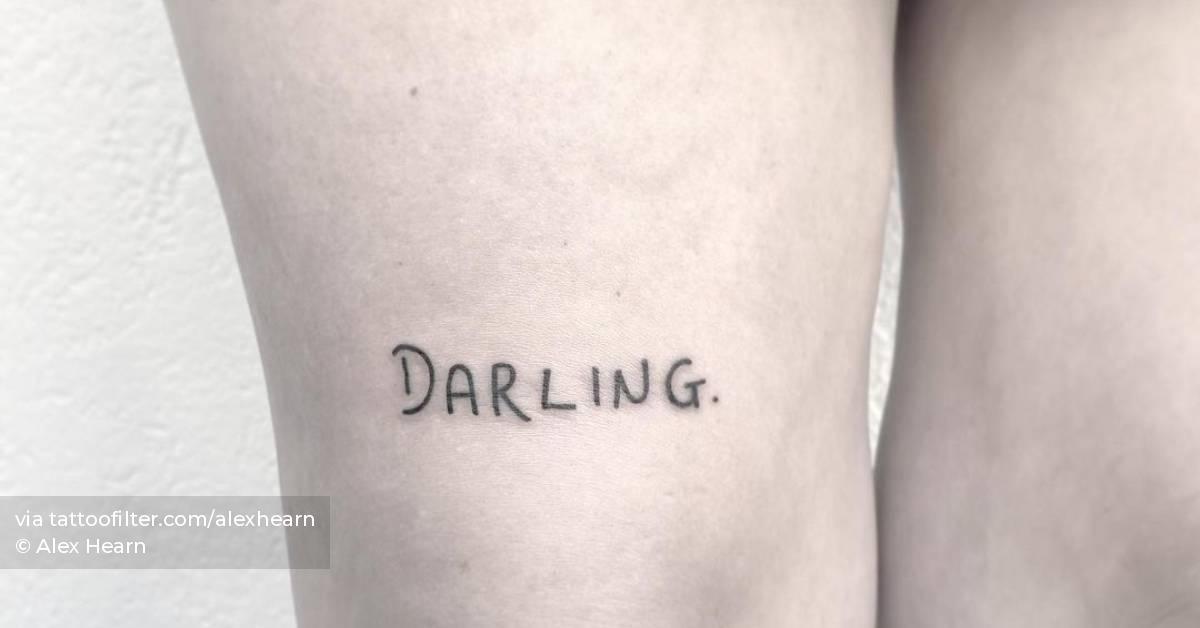 "Darling" lettering tattoo on the thigh.
