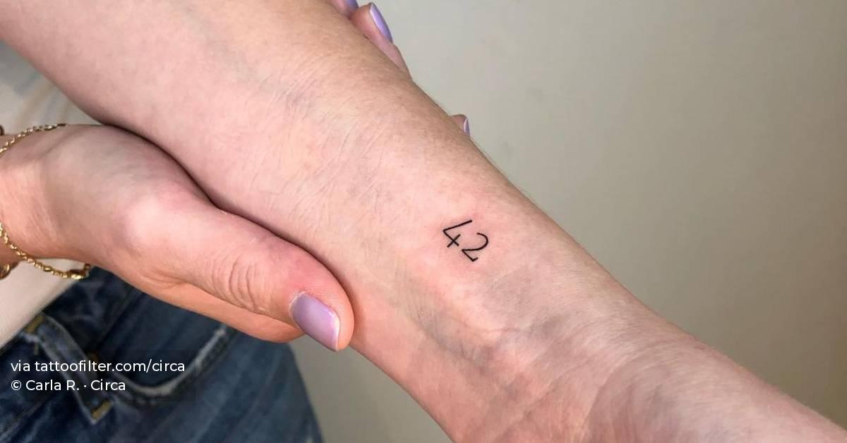 "42" lettering tattoo on the wrist.