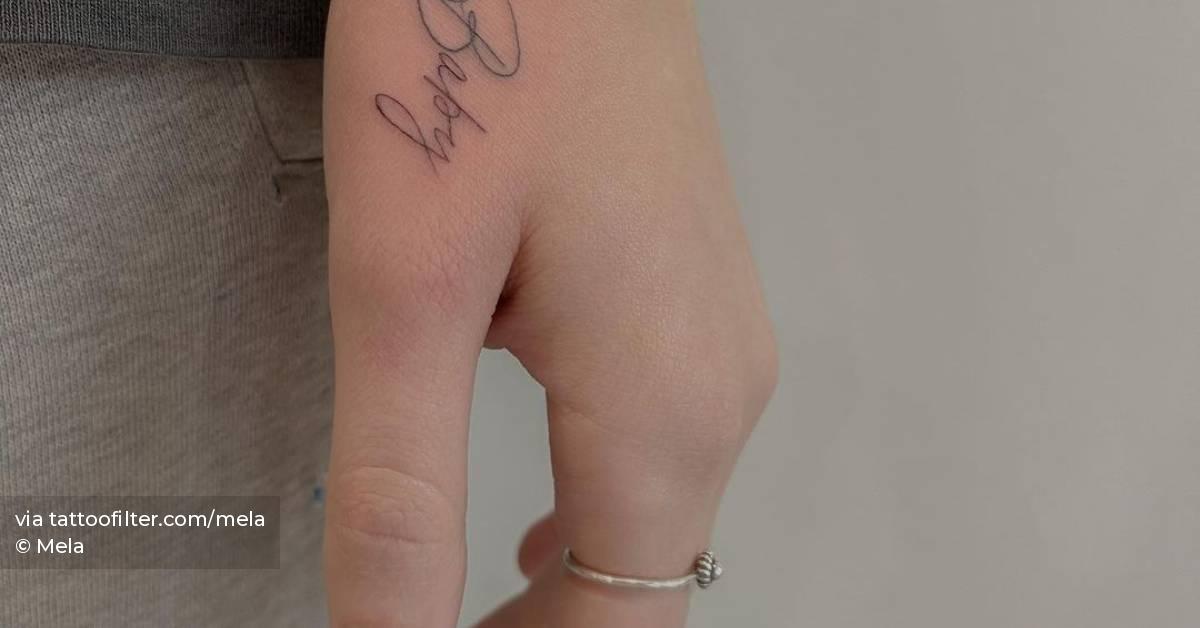 "Baby" lettering tattoo on the hand.