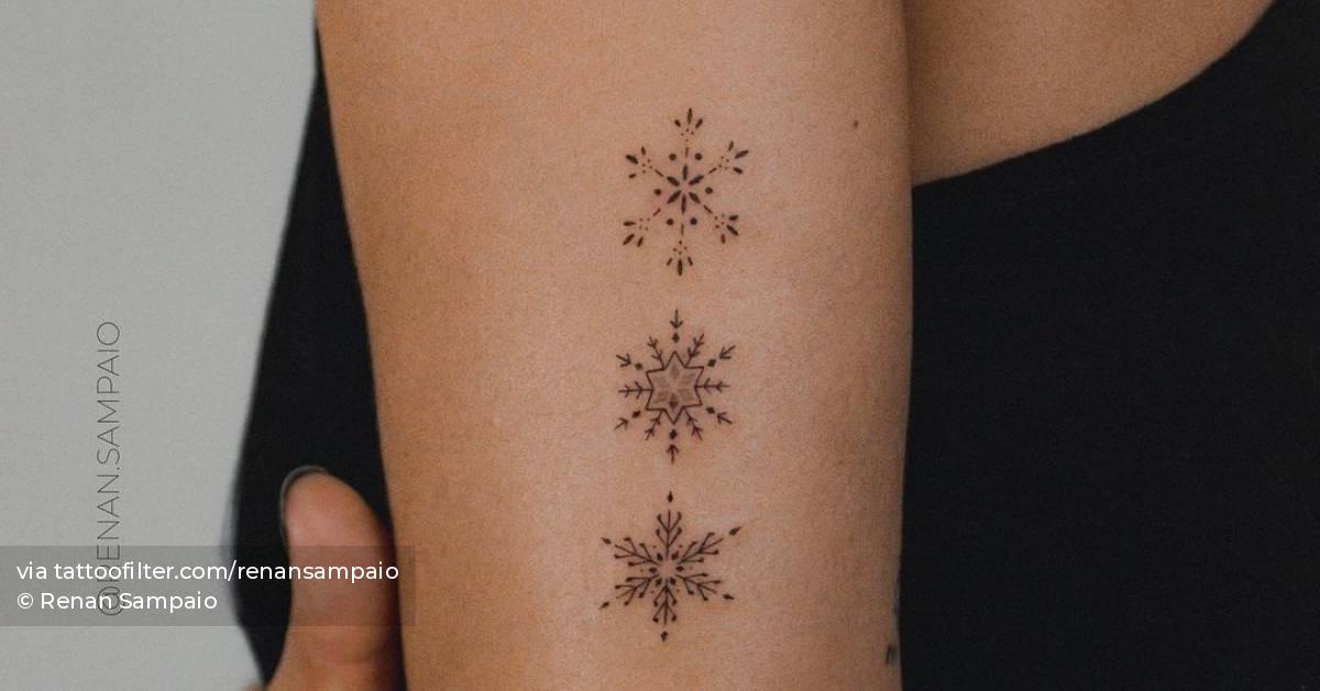 Fine line snowflakes tattoo on the tricep.