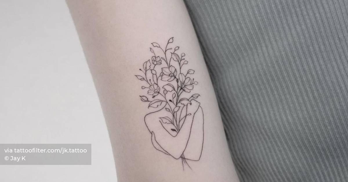 Self love - flower head woman tattoo on the tricep