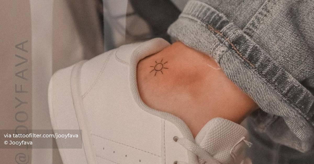 Minimalist sun tattoo on the ankle.