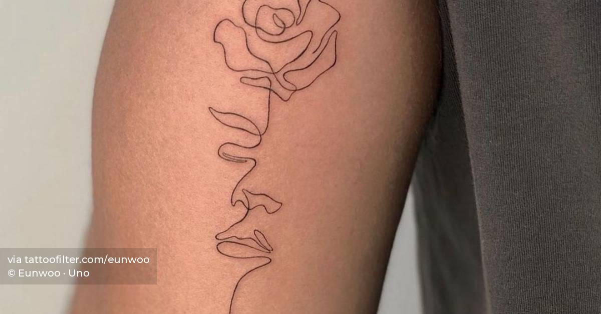 One line flower head woman tattoo on the tricep.