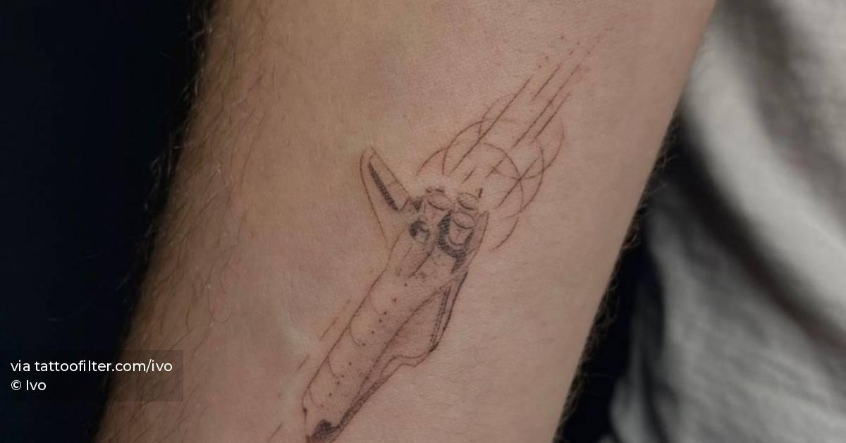 Fine line space shuttle tattoo on the inner forearm.