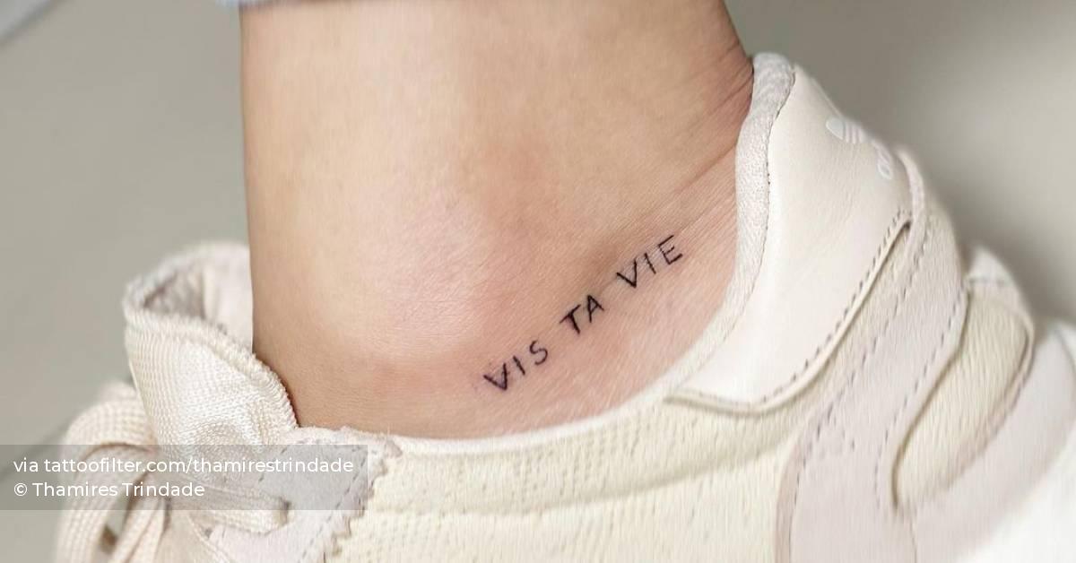 "Vis ta vie" lettering tattoo on the ankle.