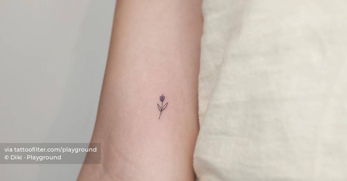 Minimalist flower tattoo on the inner arm.