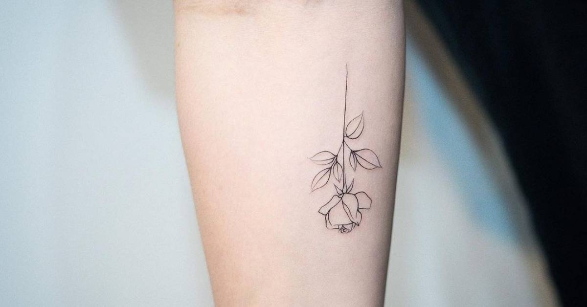 Fine line rose tattoo on the inner forearm