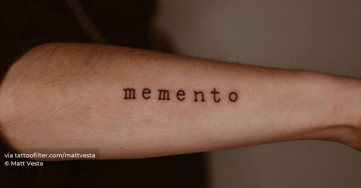 "Memento" lettering tattoo on the forearm.
