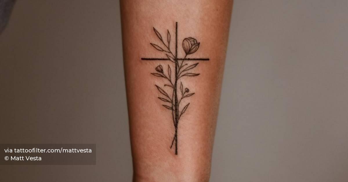 Fine line flower cross tattoo on the wrist.