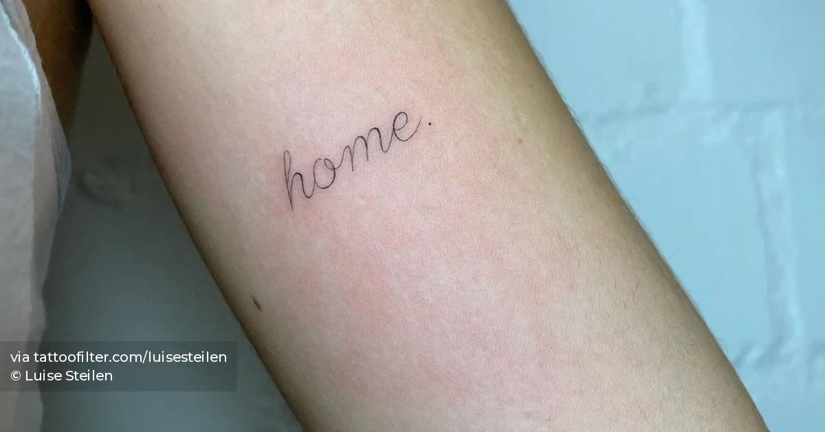 "Home" lettering tattoo on the inner arm.
