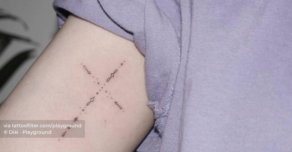Symbol chain cross tattoo on the inner arm.