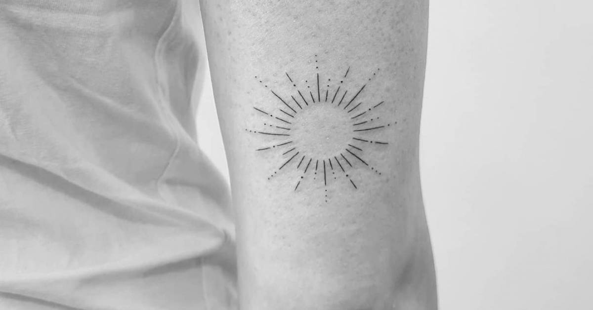Fine line sun tattoo on the tricep.