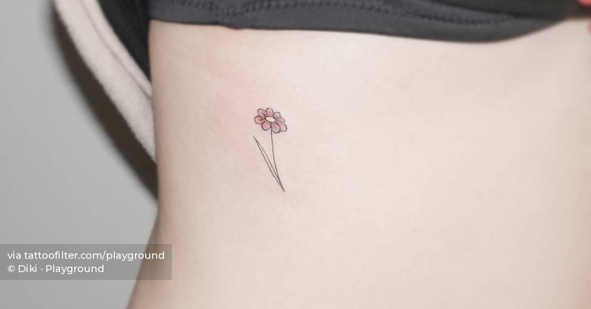 Minimalist flower tattoo on the rib.