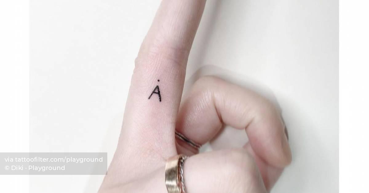 Minimalist letter "A" tattoo on the finger.