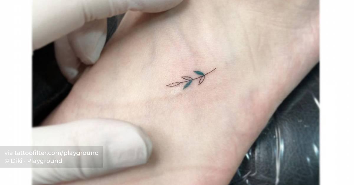 Minimalist sprig tattoo on the foot.