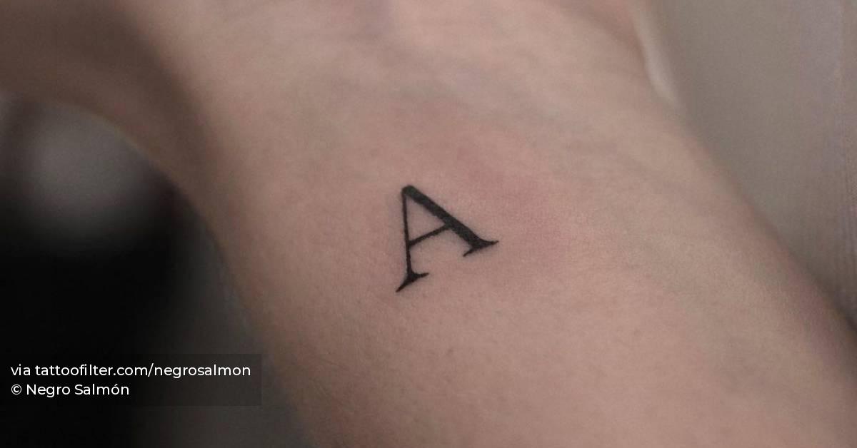 Minimalist letter "A" tattoo on the wrist.