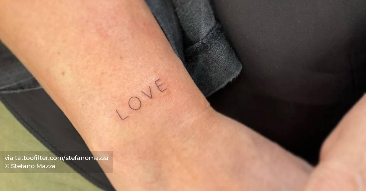 "Love" lettering tattoo on the wrist.