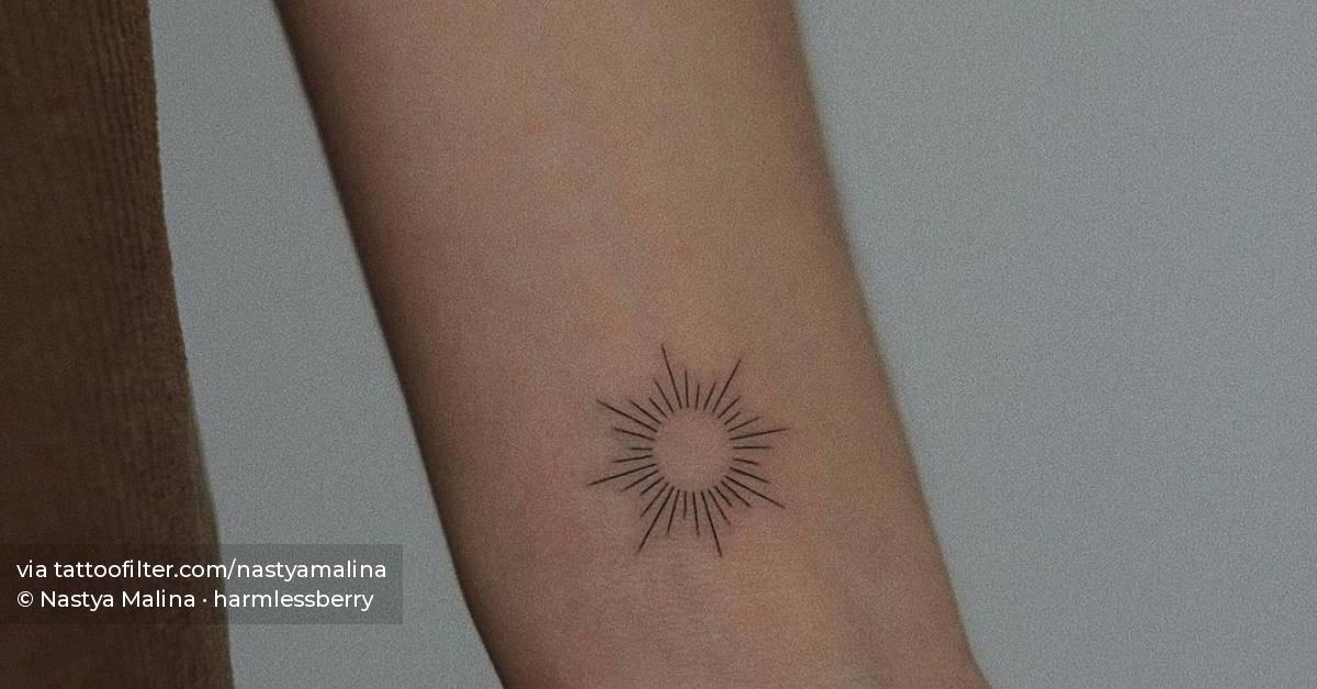Fine line sun tattoo on the wrist.