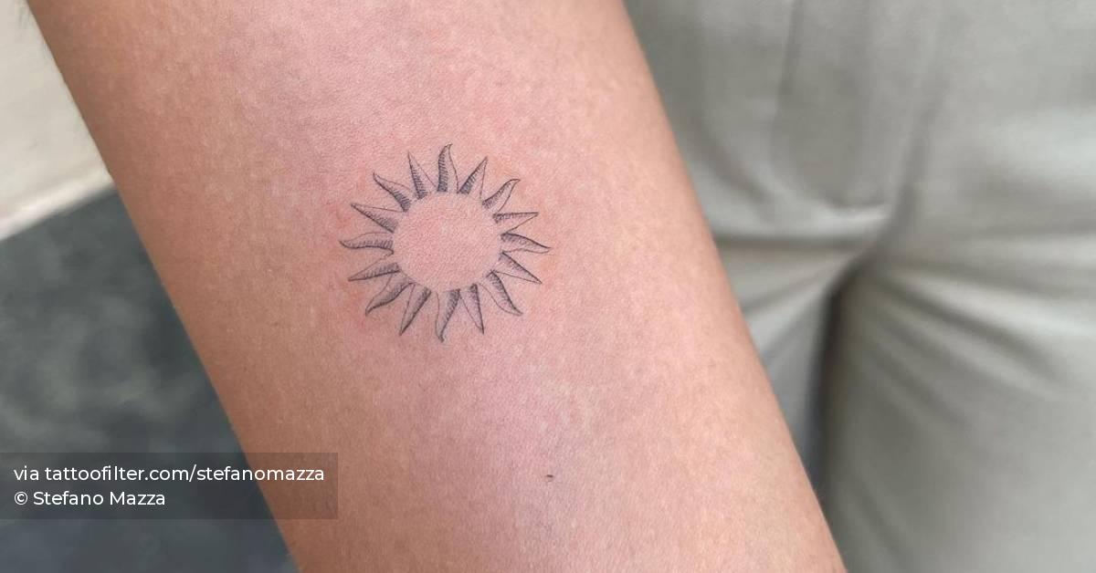 Fine line sun tattoo on the inner forearm.