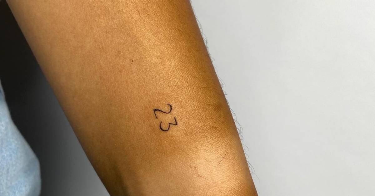 Hand poked "23" lettering tattoo on the wrist.