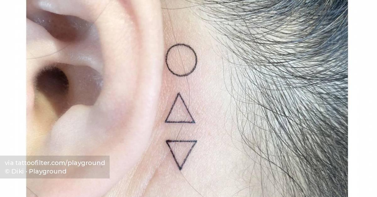 Minimalistic circle and triangle tattoo located behind