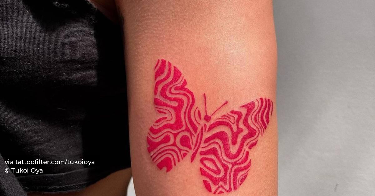 Funky patterned butterfly tattoo on the upper arm.