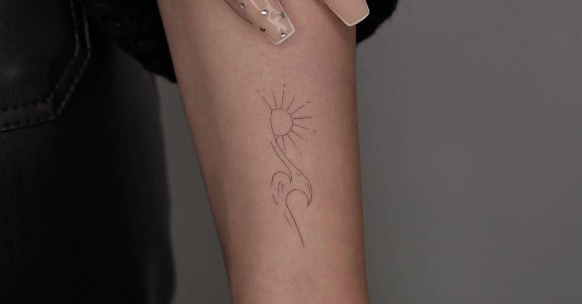 Sun and wave tattoo, done in fine line, on the wrist.