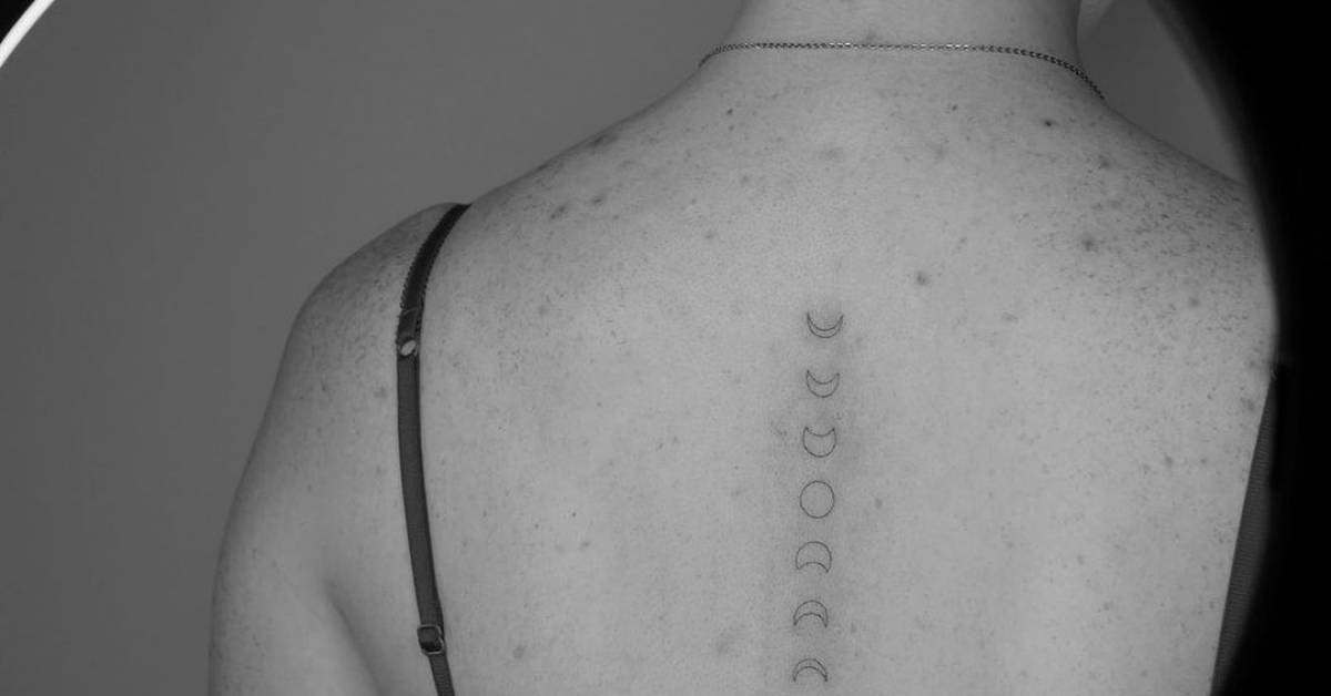 Moon phases tattooed on the upper back.