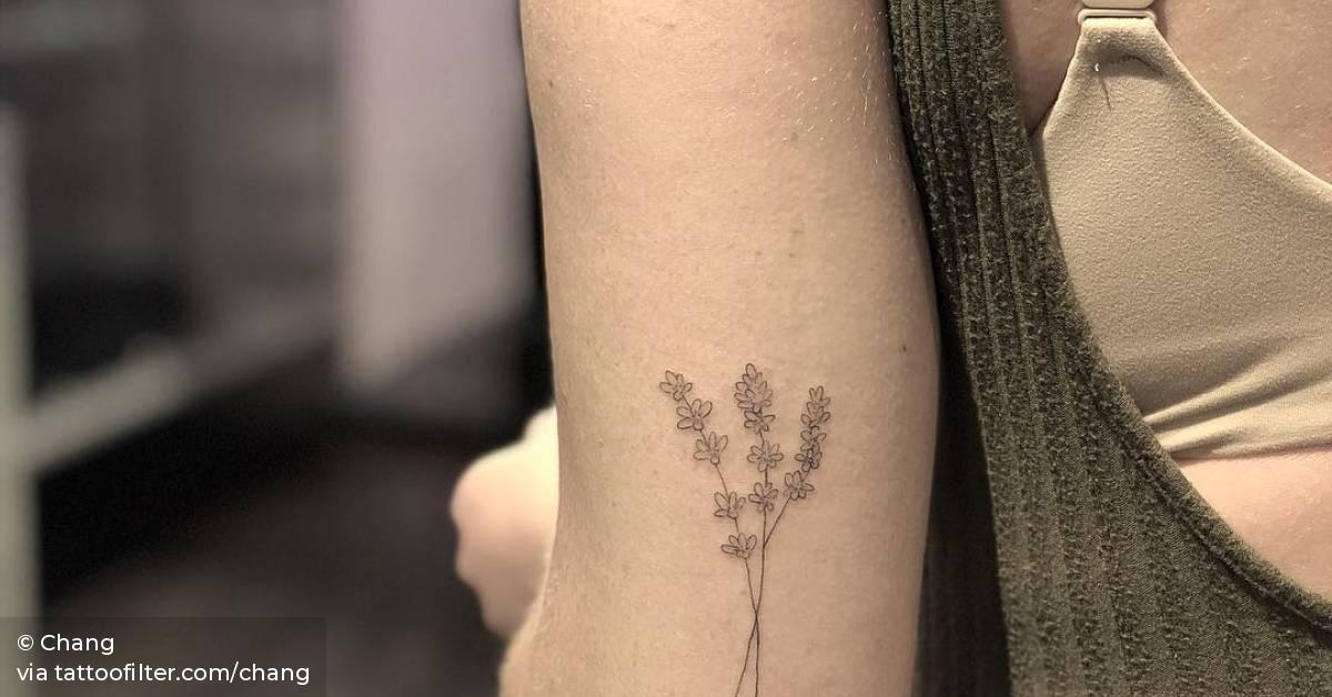 Fine line lavender tattoo on the back of the left arm.