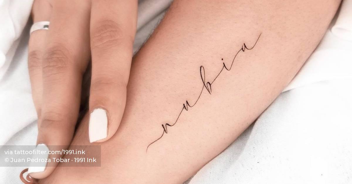 Name "Nubia" tattooed on the forearm.