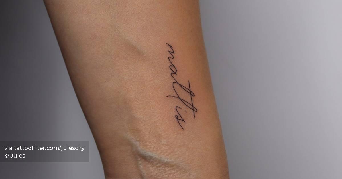 Handwritten lettering tattoo located on the wrist.
