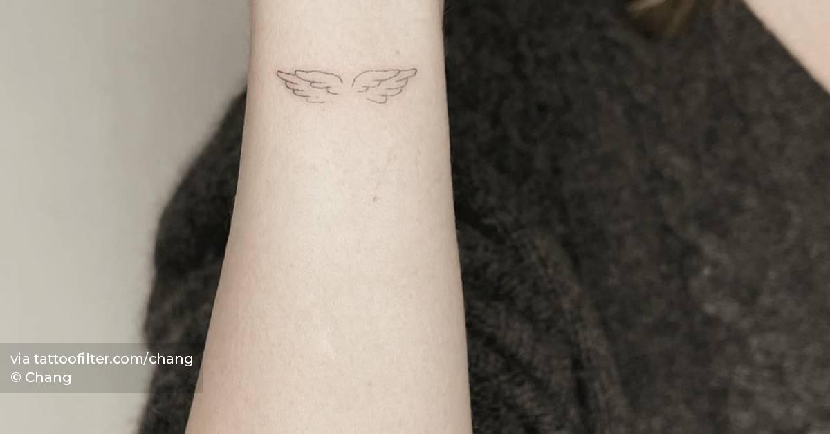 Fine line wings tattooed on the wrist.