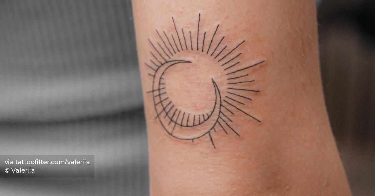 Fine line sun and moon tattoo located on the tricep.