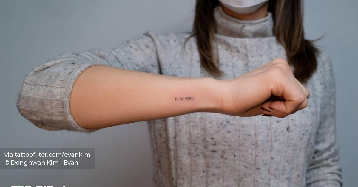 Roman numerals tattoo located on the wrist.