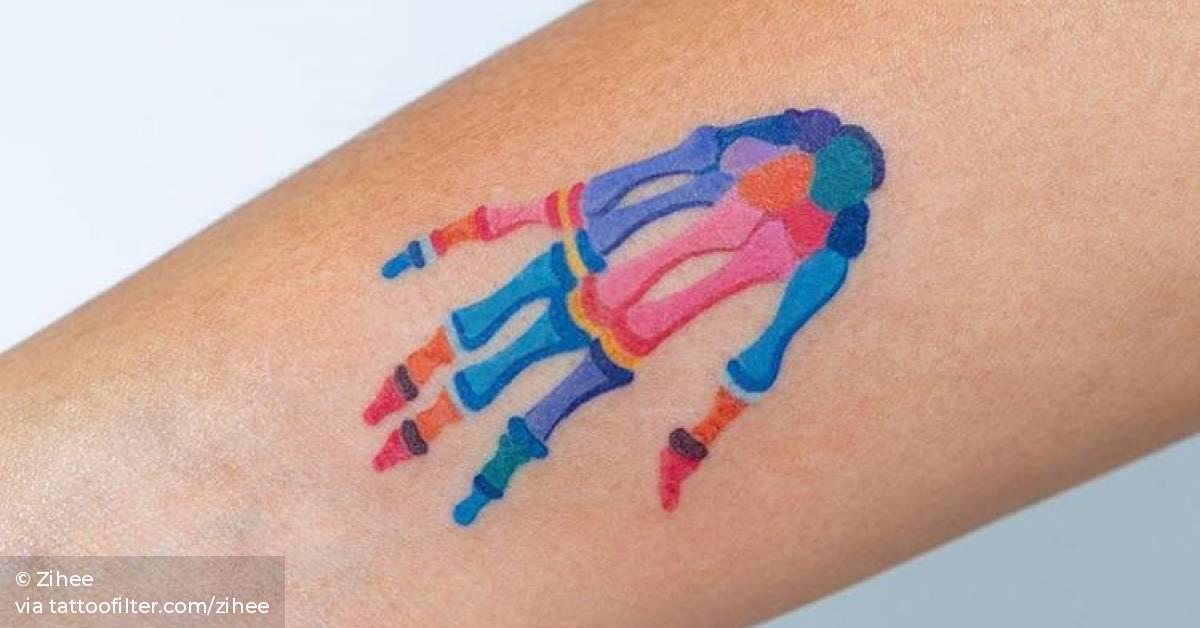 Skeleton hand tattoo on the inner forearm.