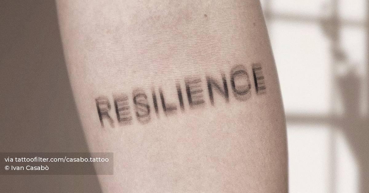 Blurry effect "resilience" lettering tattoo located on