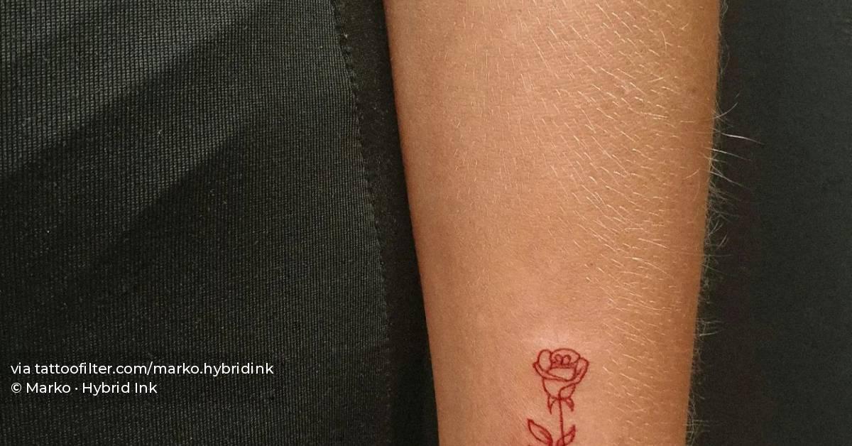 Fine line red rose tattoo located on the wrist.