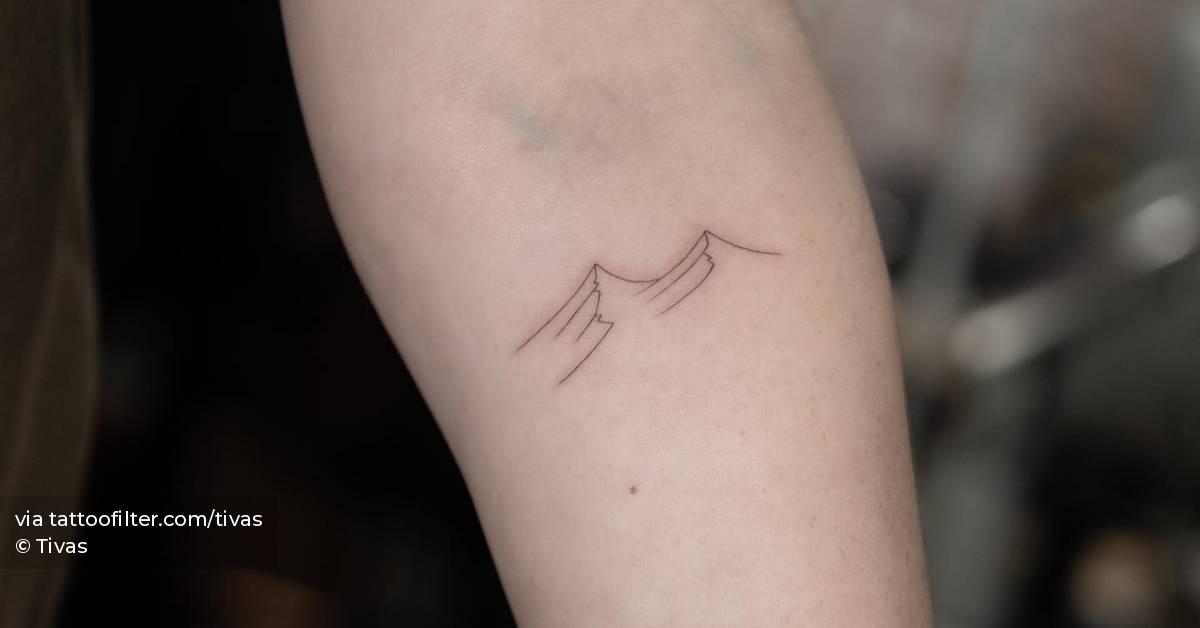 Minimalistic mountain tattoo done in fine line, located