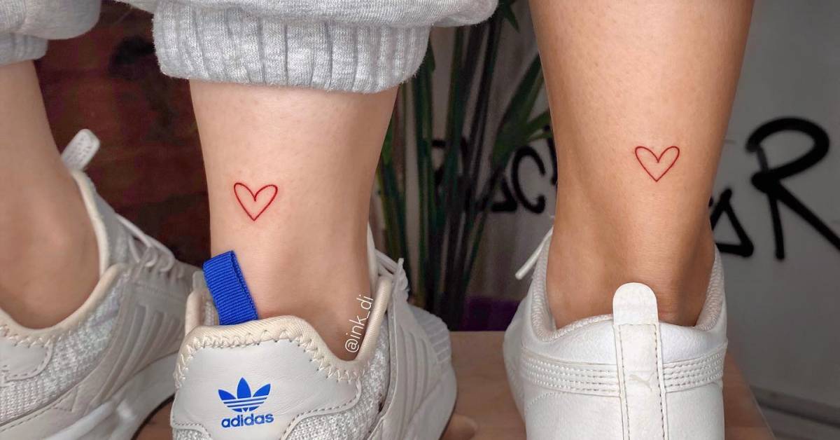 Matching minimalist red heart tattoo for couple.