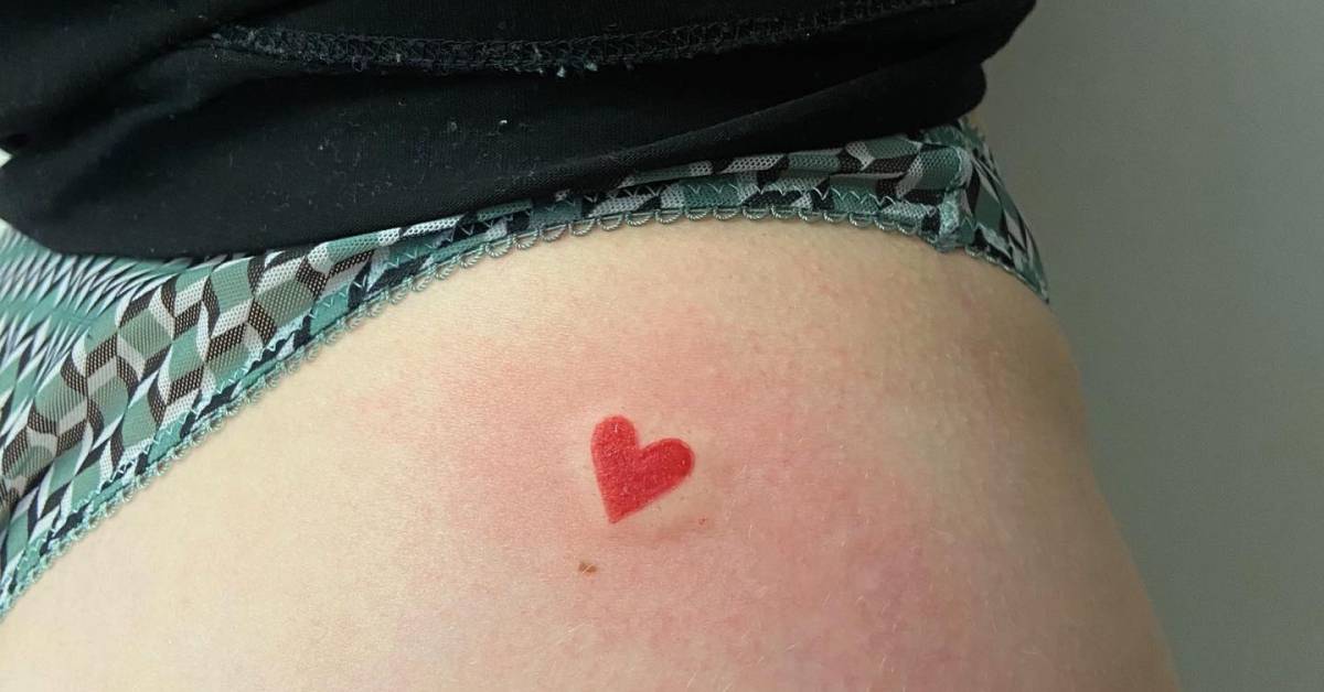 Small red heart tattoo done on the hip.