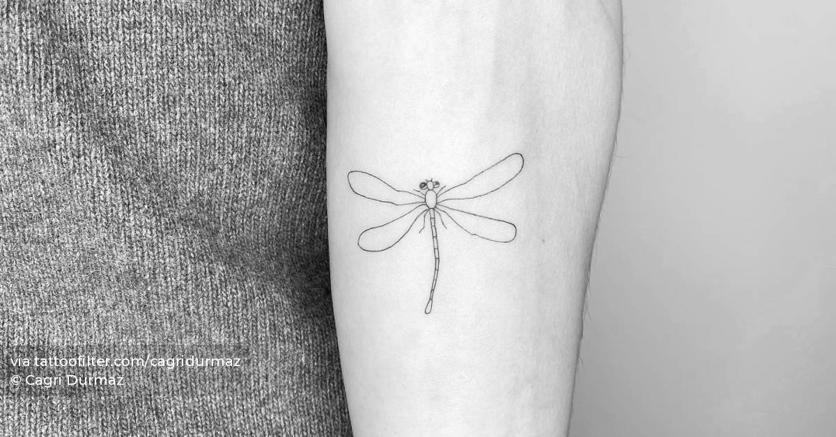 Fine line dragonfly tattoo located om the inner