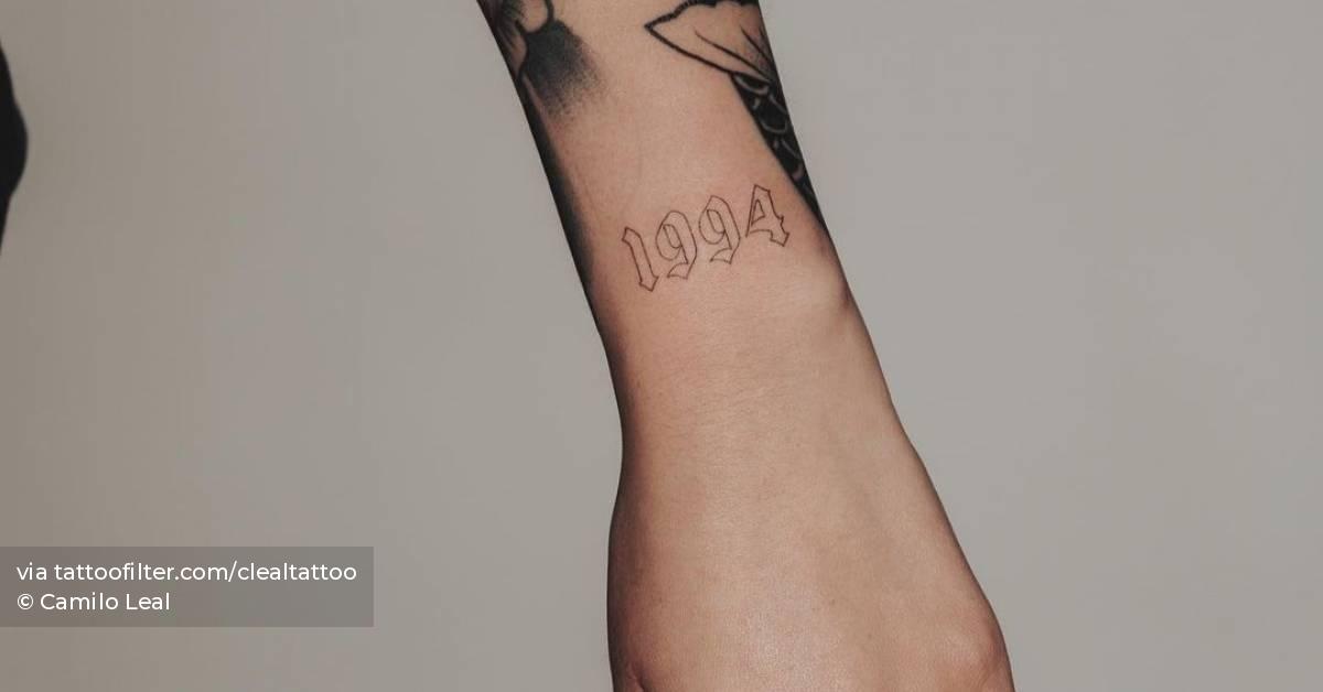 "1994" lettering tattoo on the wrist