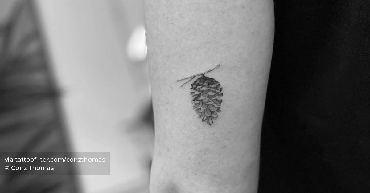 Micro-realistic pine cone tattooed on the tricep.