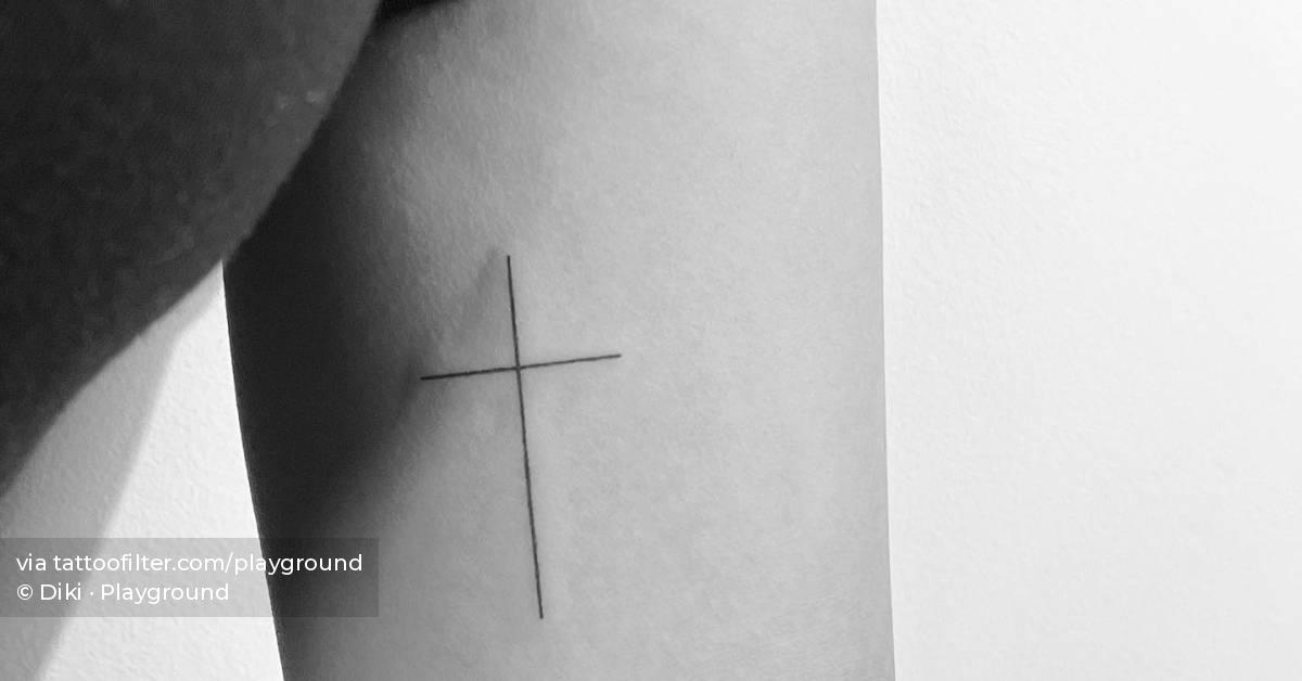 Minimalistic style cross tattoo done on the inner arm.