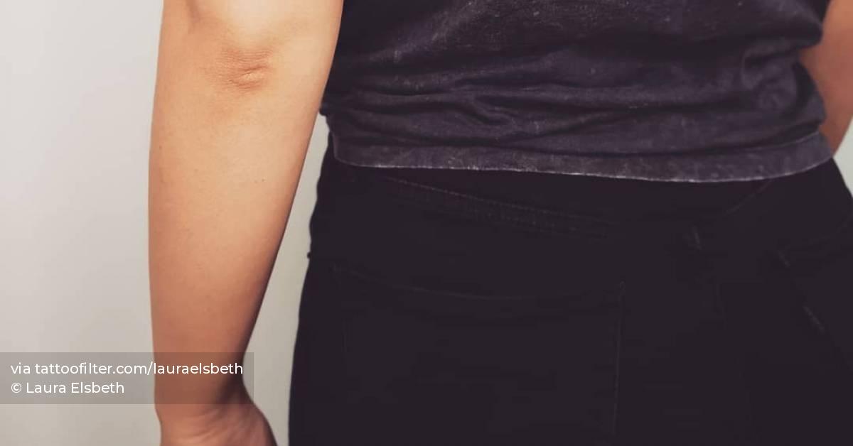 Hand poked "1972" lettering tattoo done on the tricep.