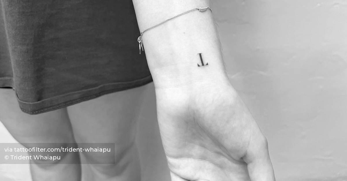 Minimalistic letter "T" tattoo done on the wrist.