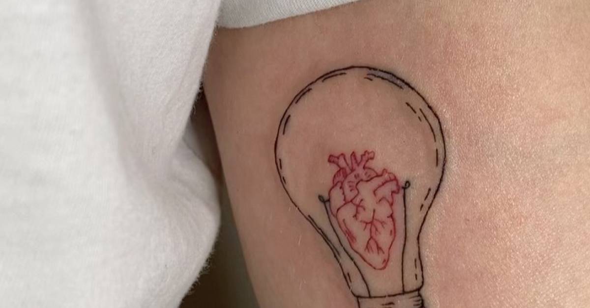 Lightbulb and heart tattoo located on the inner arm.