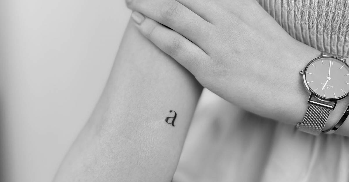Minimalistic letter "a" tattoo done on the inner arm.