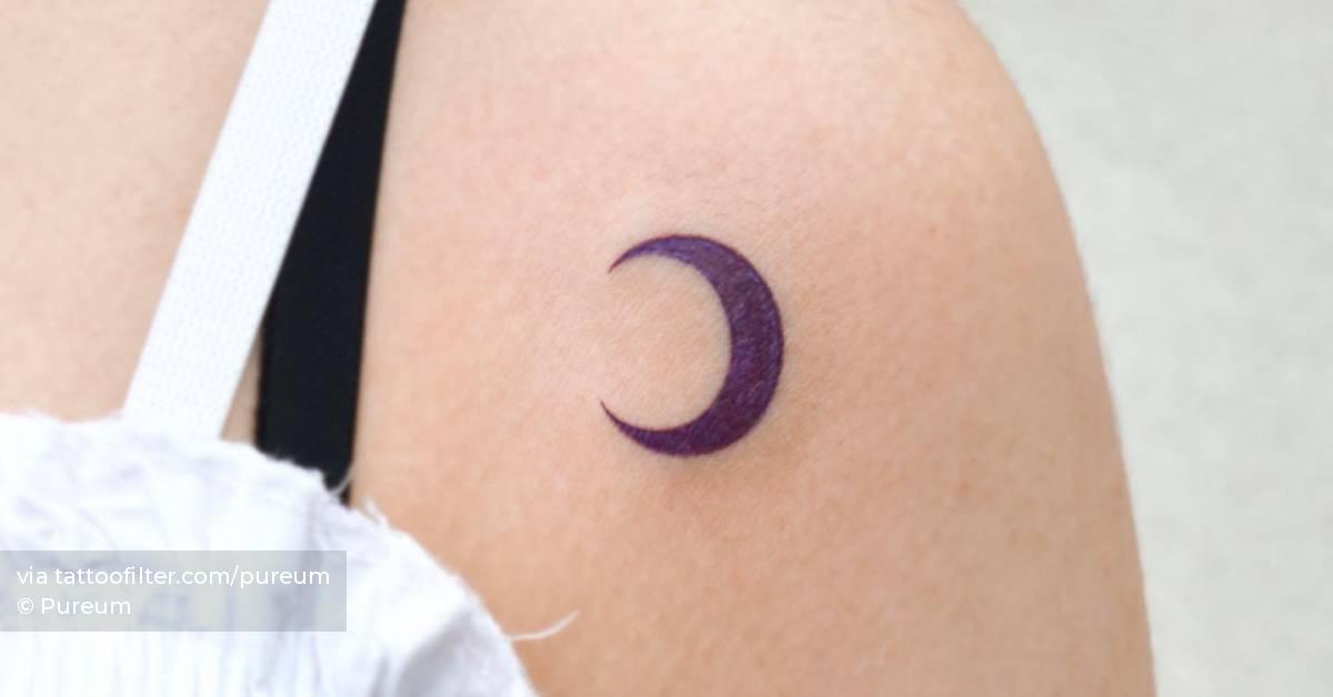 Purple crescent moon tattooed on the shoulder.