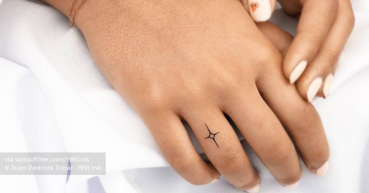 Minimalistic star tattoo located on the finger.